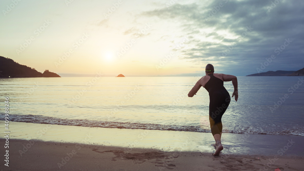 Back view of unrecognizable professional swimmer in swimsuit and cap ...