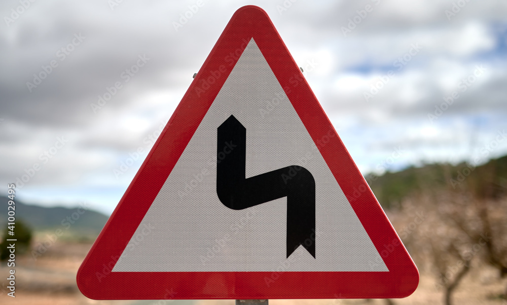 triangular traffic sign depicting a sharp turn, with red border Stock ...