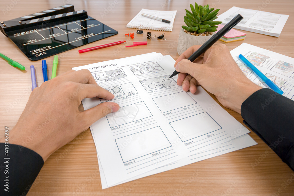 Hand with writing storyboard with clapperboard to present process to ...