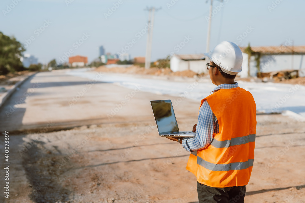 Civil engineer at construction site using computer laptop checking work ...
