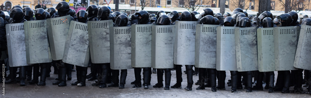 Line of police riot forces, protest in city. Uniform armor with shields ...