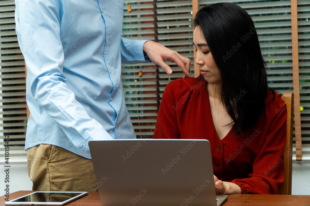 Boss touching shoulder of a young female employee in office at ...