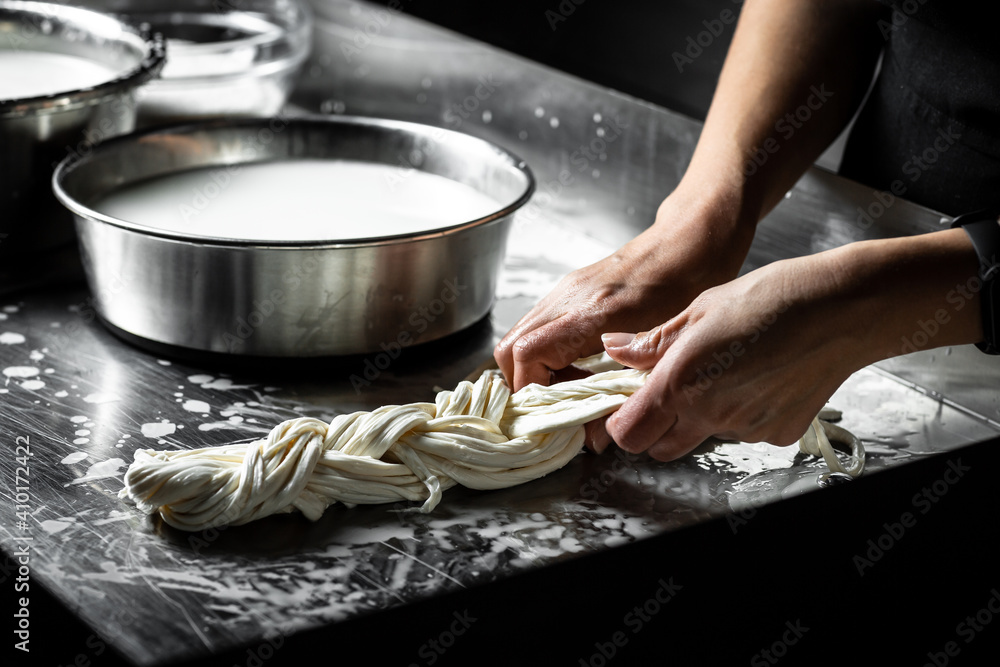 Production process of mozzarella cheese. woman working in a small ...