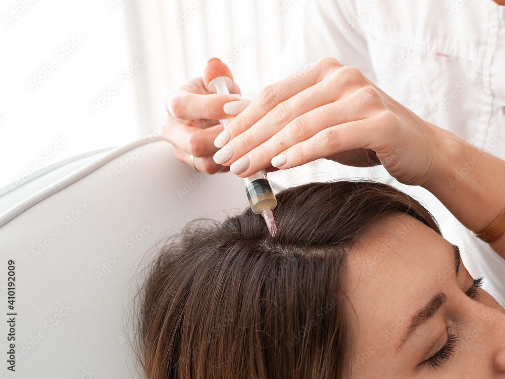 Young woman with hair loss problem receiving injection, close up ...