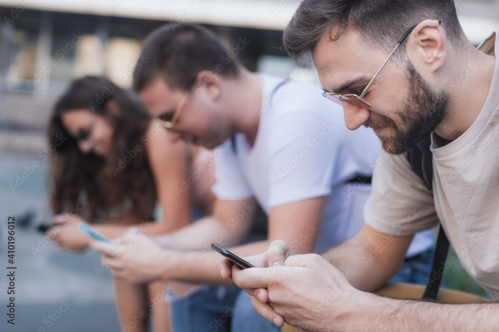 Group of friends using smartphones together. Young people addiction to ...