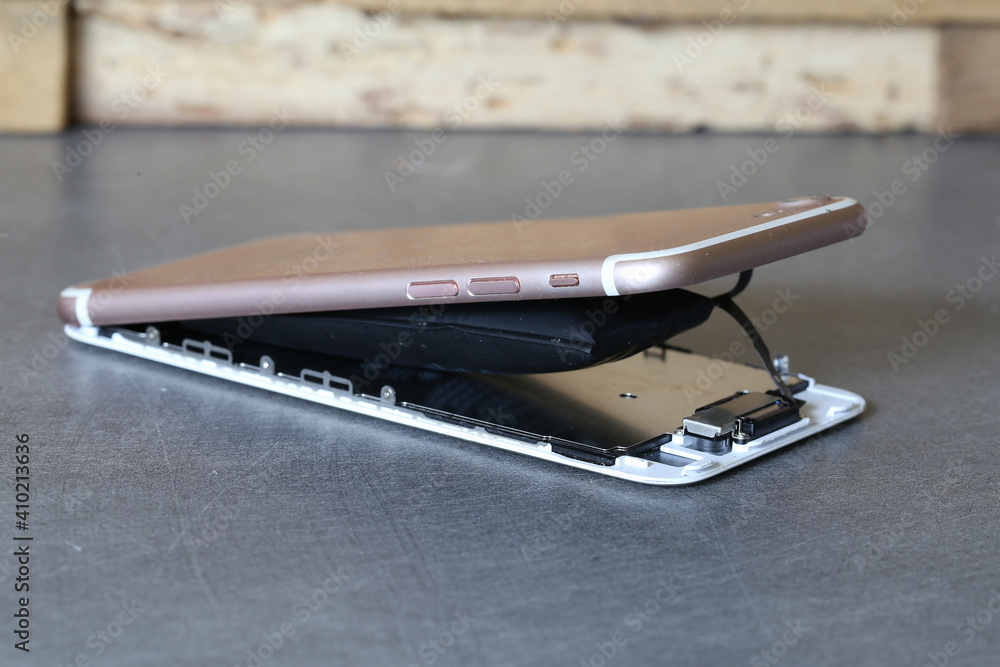 Smartphone défectueux : écran cassé et batterie gonflée sur un bureau ...