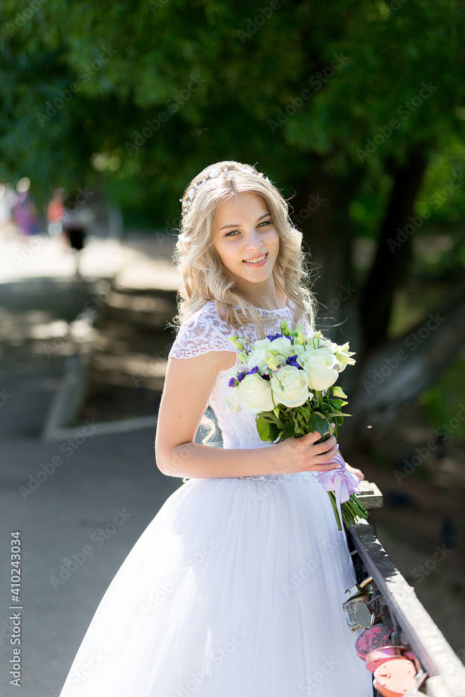 Beautiful bride in a fashionable wedding dress on a natural background ...