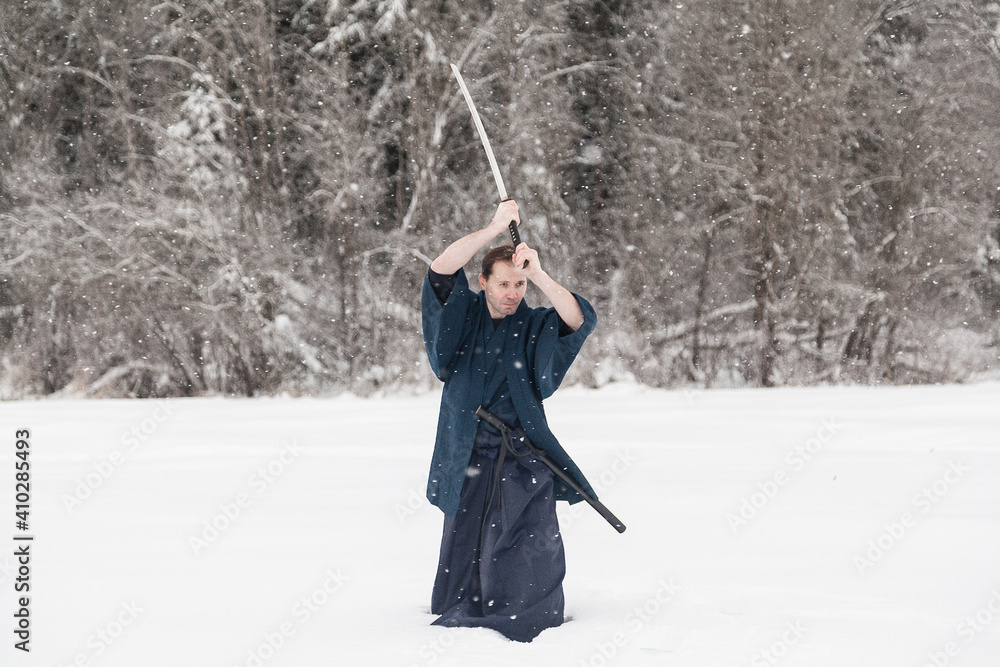 samurai warrior stands with sword and staff in the middle of an empty ...