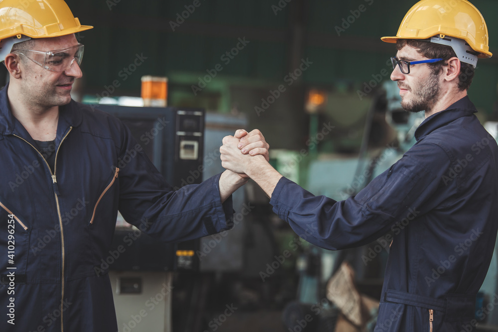 male workers and protective uniform shaking hands while working success ...