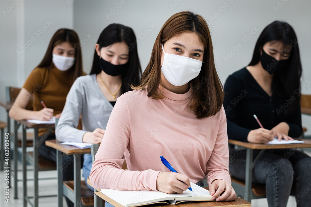 Group of college students wearing a face mask and keep distance while ...