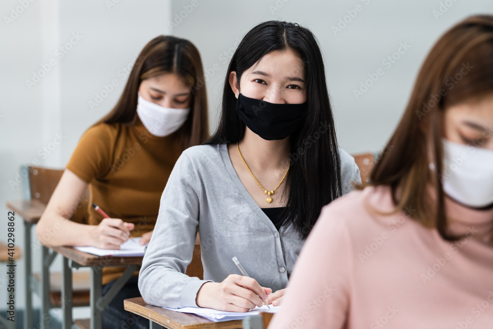 Group of college students wearing a face mask and keep distance while ...