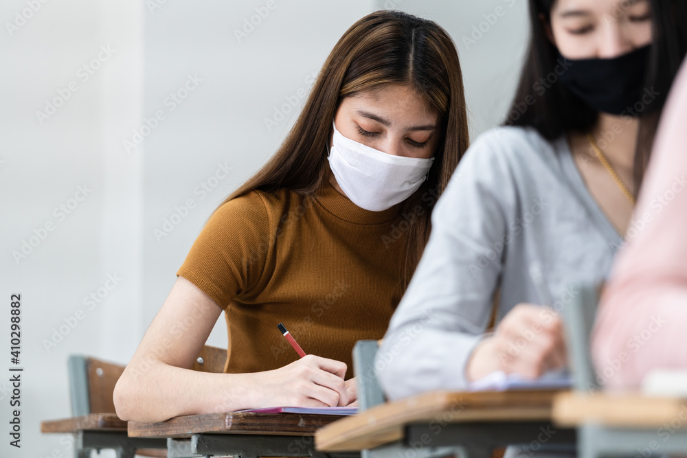 Group of college students wearing a face mask and keep distance while ...