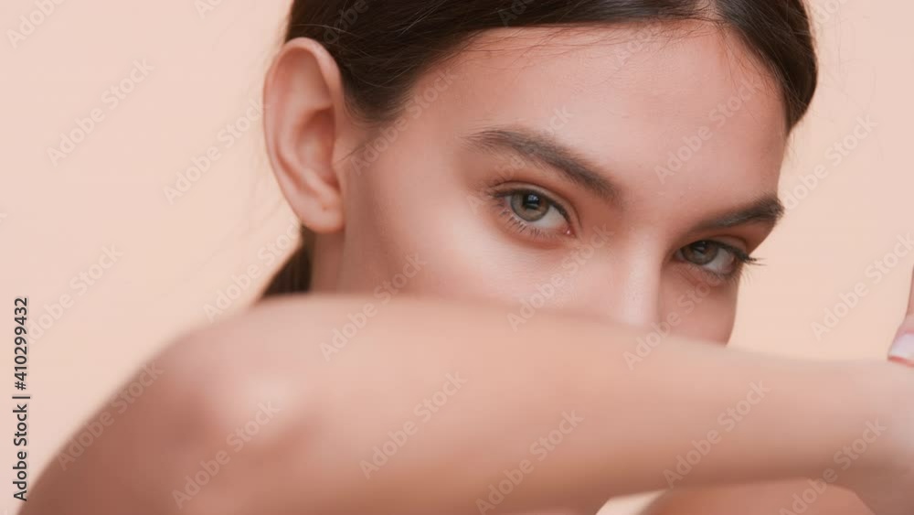 Beauty model touches her hand skin with a finger and looking through ...