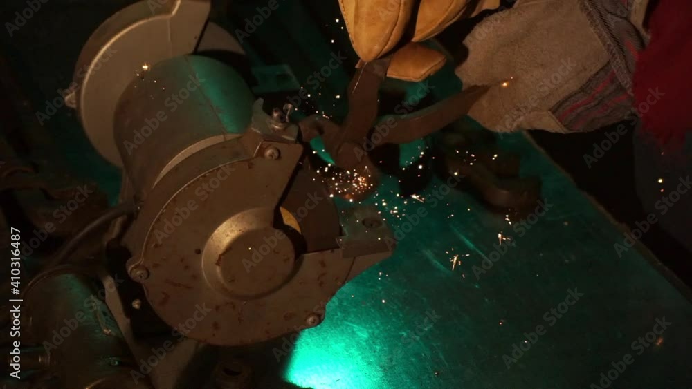 Slow motion of tool sharpened on bench grinder. Fast shutter speed ...