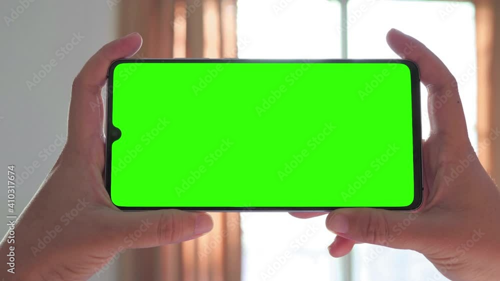 Horizontal hands holding smartphone with green screen. Green screen ...