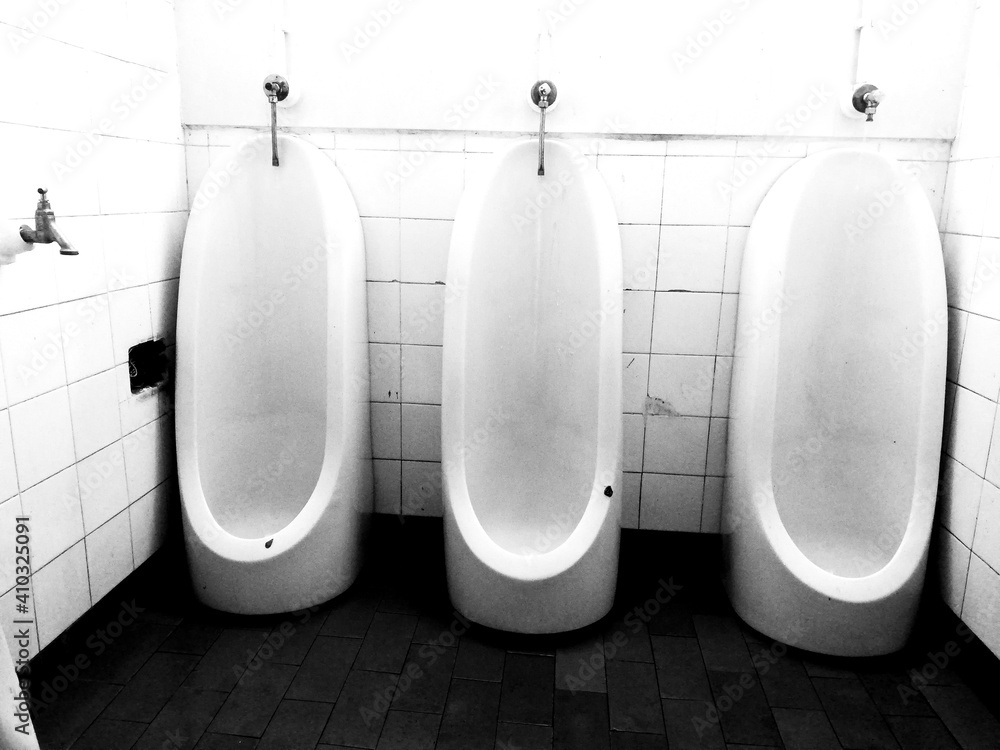 The interior of old dirty Public toilet urinals in men toilet with very ...