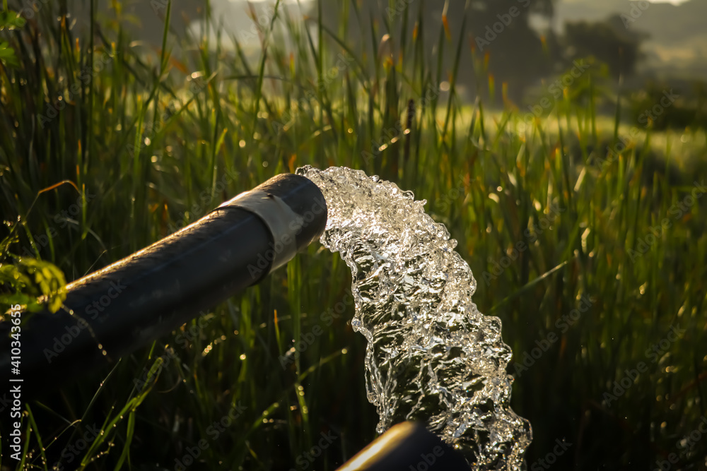 Pumping water out of plastic pipe into the ground,Water from a well ...
