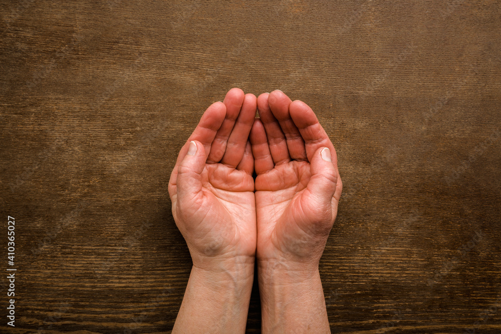 Opened old woman palm on dark brown wooden table background. Empty ...