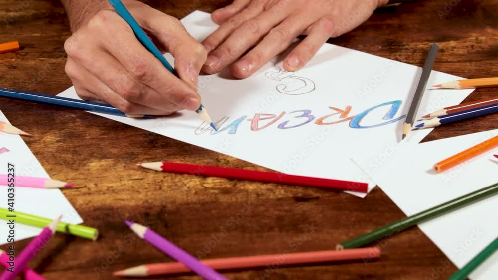 Panning across a Caucasian artist's work table staying focused on his ...