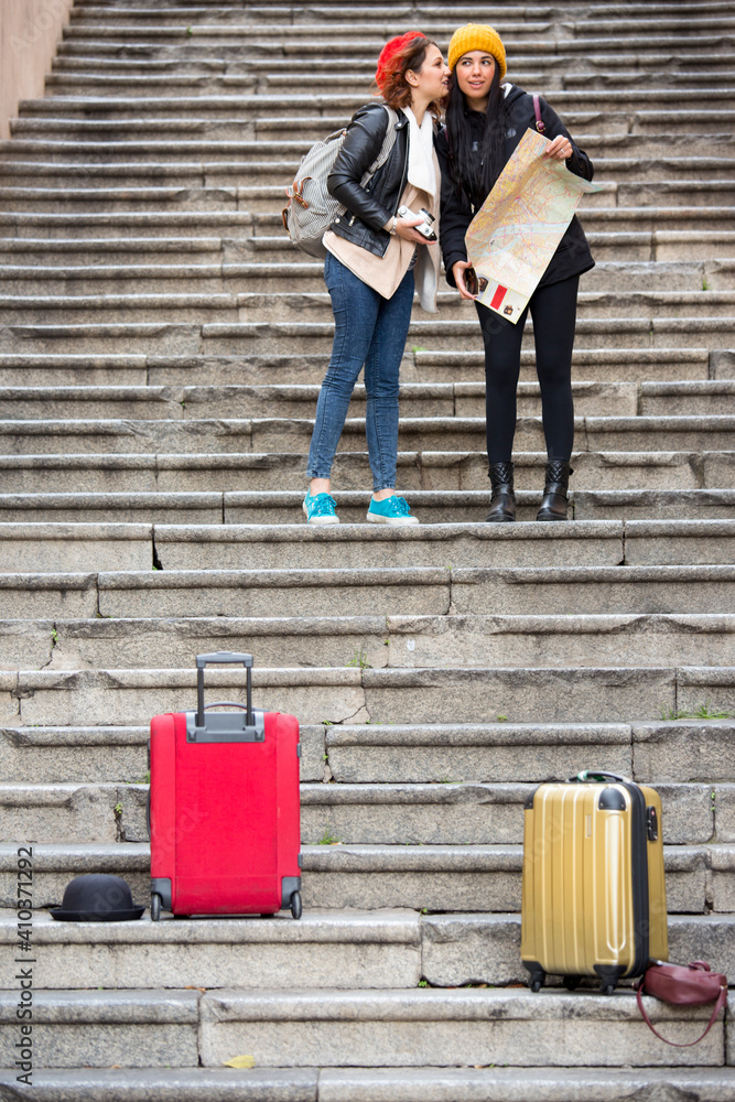 Fotka „coppia di amiche in viaggio controlla la mappa in un scalinata ...