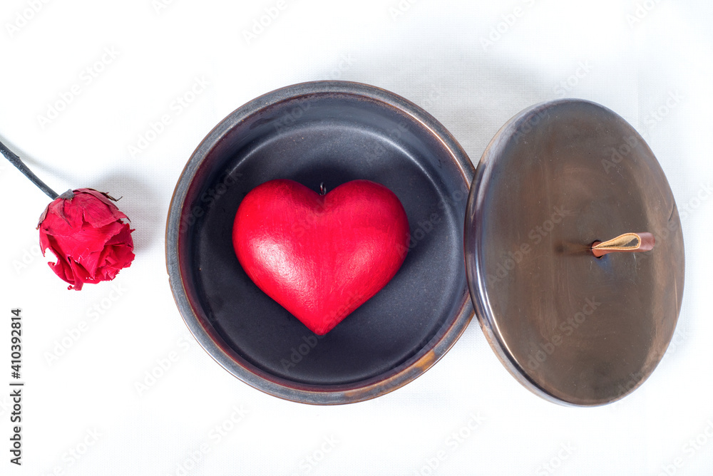 Top view on a red love heart inside a round gift box and a red rose ...
