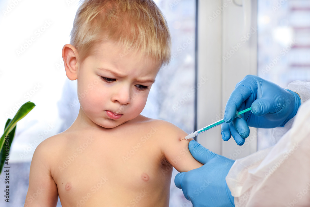 Doctor injecting vaccination in arm of a little boy. Coronavirus ...