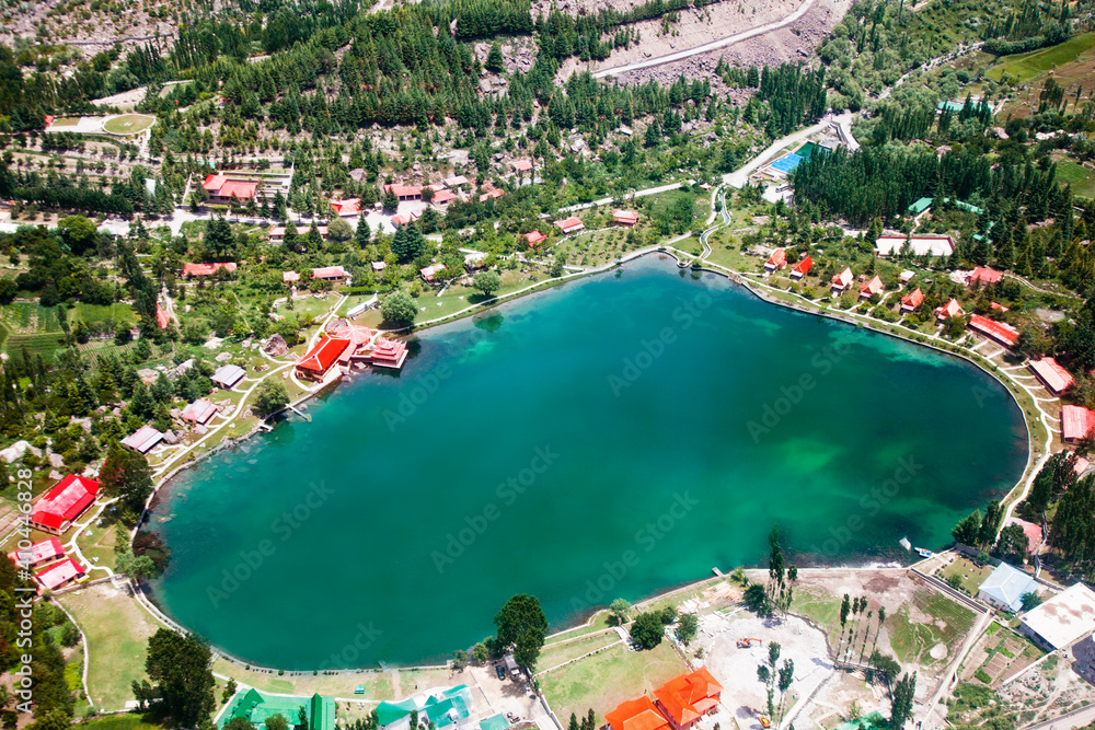 aerial view of a beautiful lake with green water red huts and lush ...