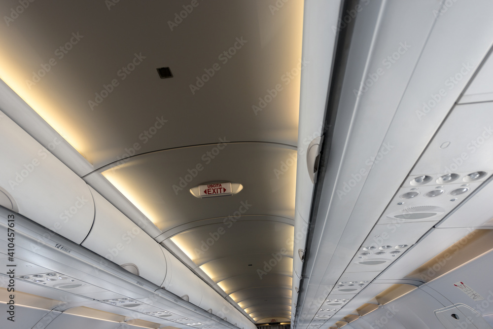 Emergency exit sign in the passenger cabin of an airplane in English ...