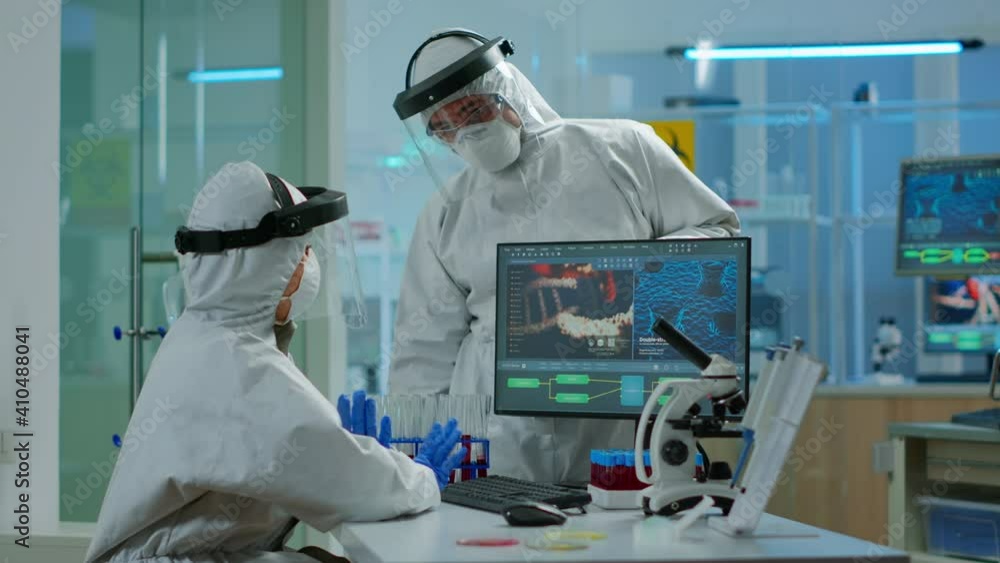 Scientist team in prorection suit arguing in front of pc looking at ...