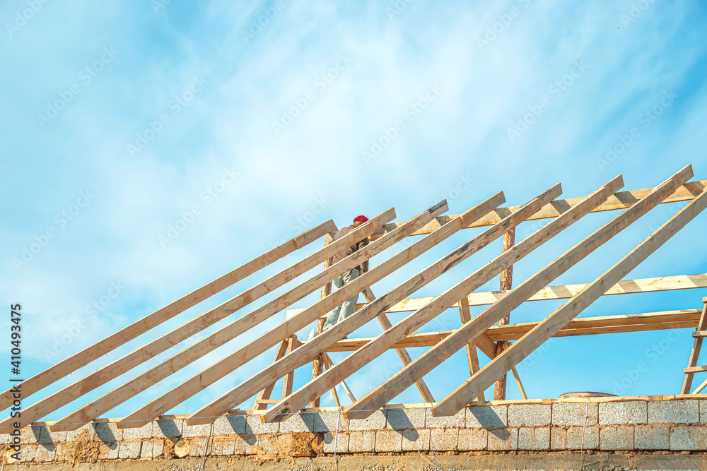 Wooden rafters against the blue sky in house under construction ...