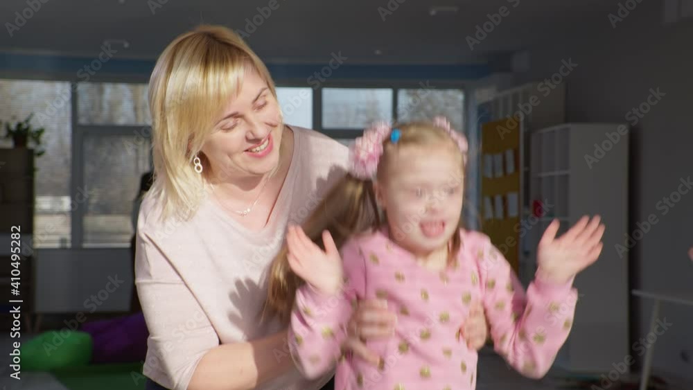 little girl with down syndrome jumping on a trampoline and claps your ...