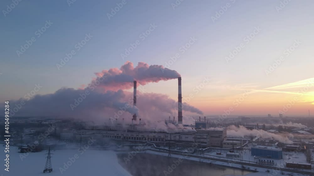 Smokestacks of factory smoke over sunrise sky background at freezing ...