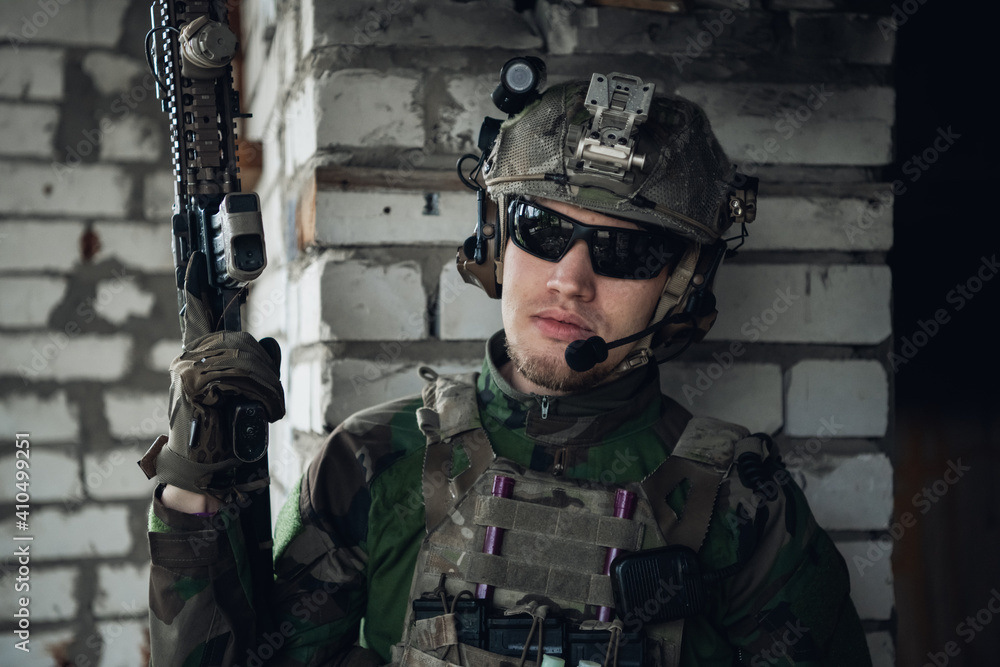 Military man with assault rifle standing inside building, he is ready ...