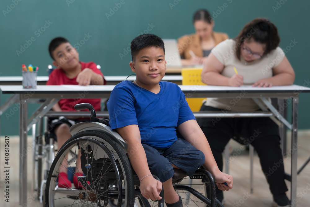 Portrait of young disabled boy with firmly eyes sitting on wheelchair ...