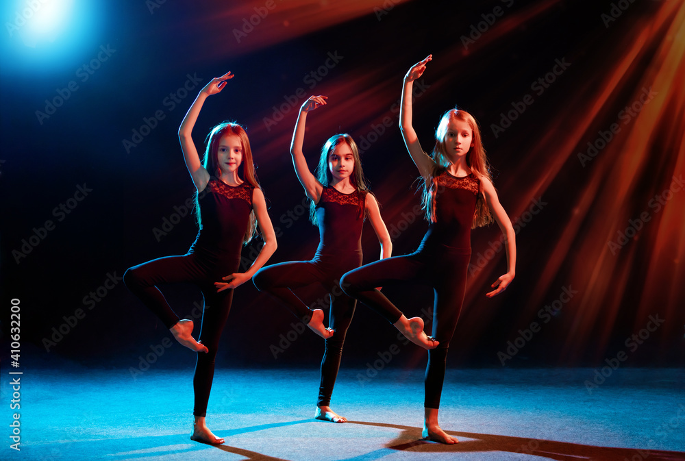 group of three ballet girls in tight-fitting costumes dance against ...