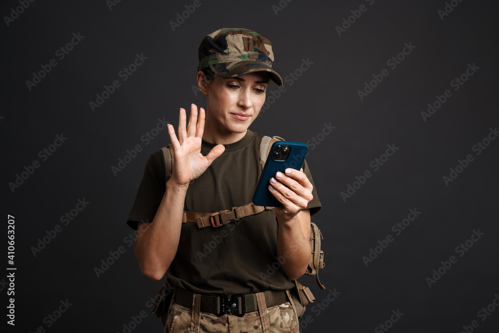 Serious beautiful soldier woman with army backpack waving hand Stock ...