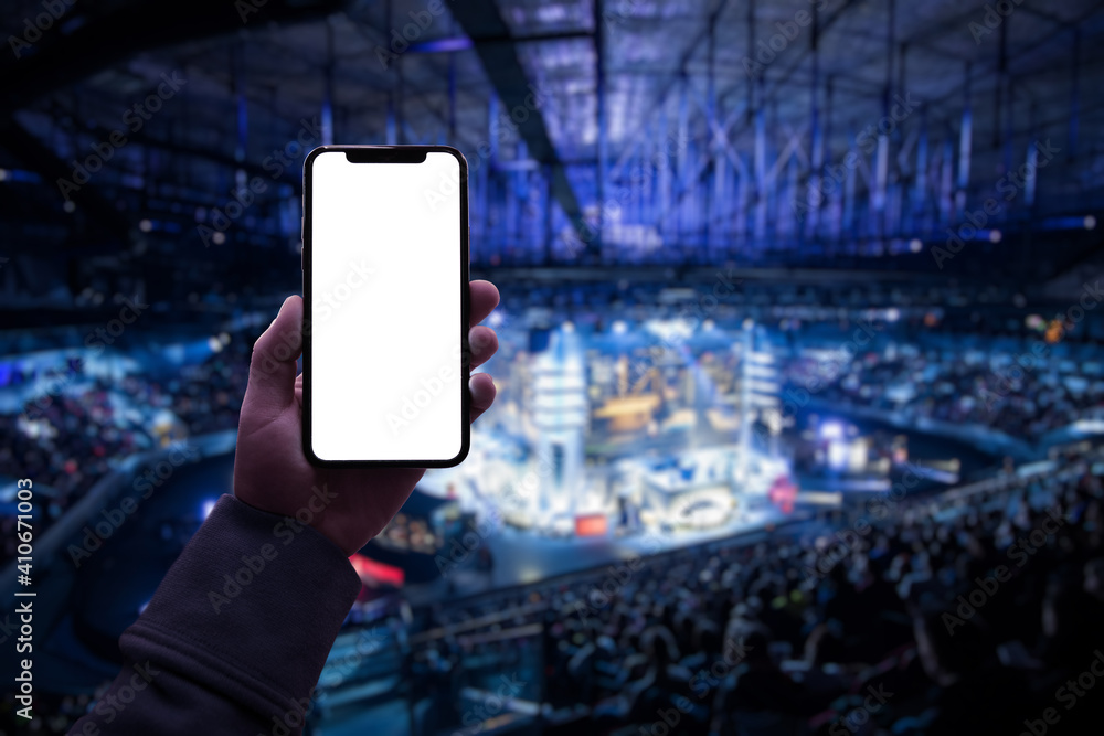 Gamer using smartphone during big esports gaming event sitting on the ...
