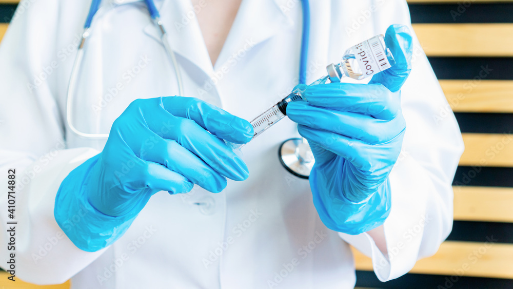 The doctor is filling a syringe with the COVID-19 vaccine. Preparation ...