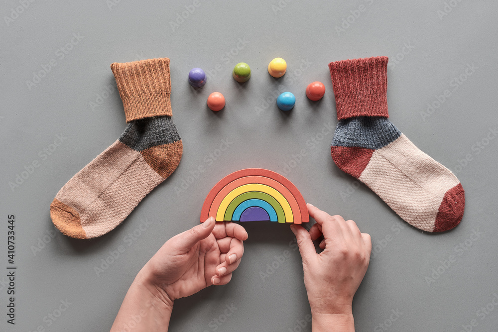 Odd Socks Day. Mismatched socks, hands holding wooden rainbow, toy ...