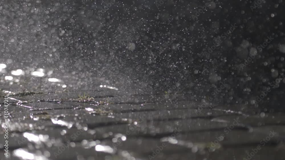 SLOW MOTION CLOSE UP: Spring rain water drops falling into big puddle ...