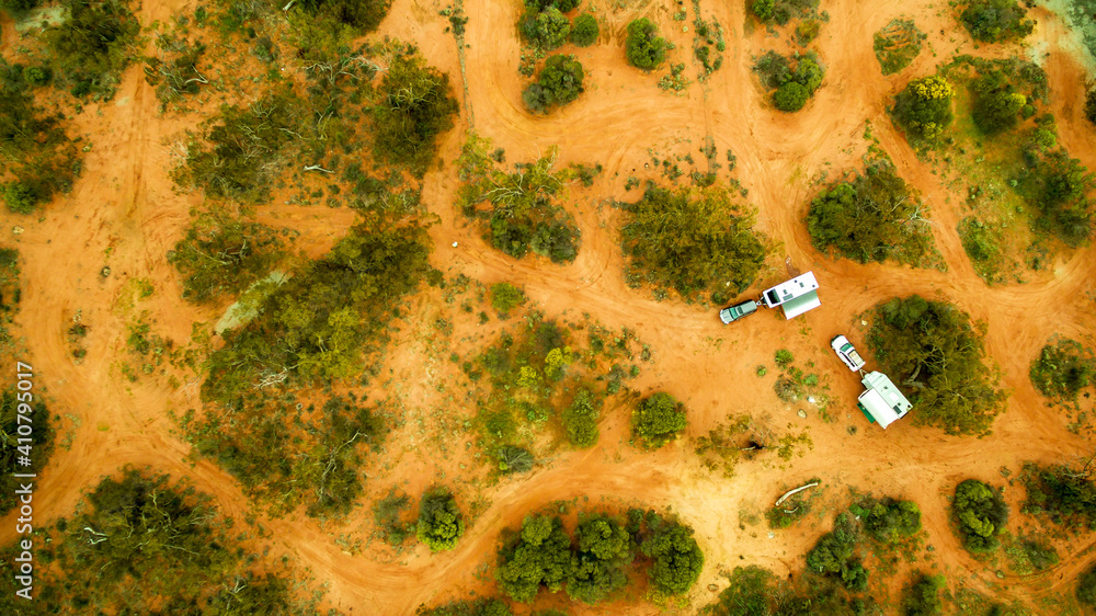 Vertical aerial view of two 4WD's with modern caravan parked at a free ...