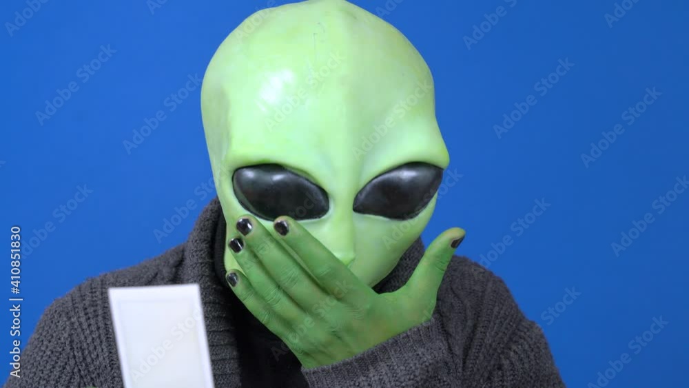 Humanoid in cozy knitted jacket looks at photo, postcard or reads note ...