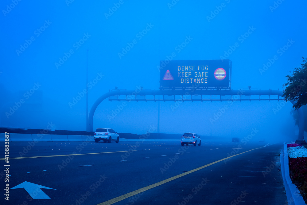 Road in the fog, sign mention keep distance for motorists at dubai road ...