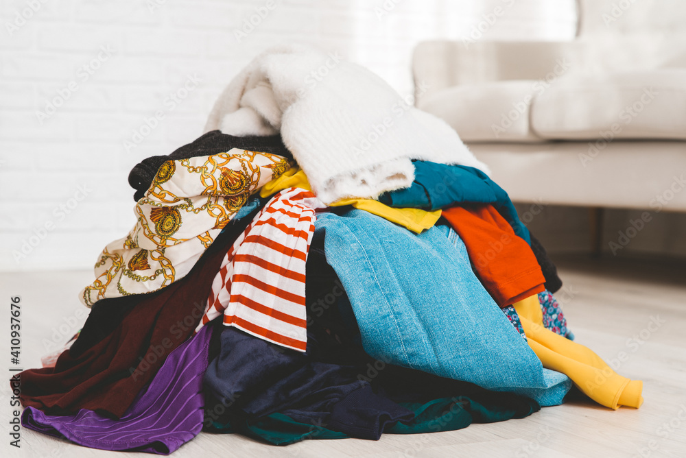 Pile of unfolded clothes for laundry on the floor. Heap of used clothes ...