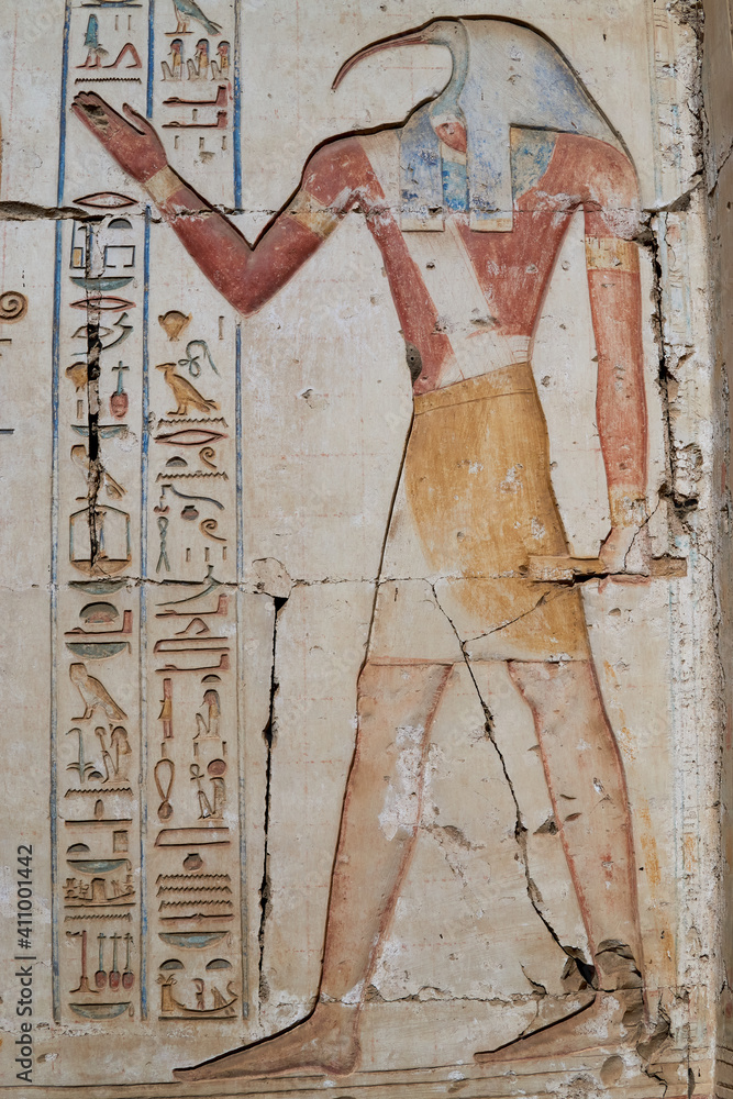 A wall relief of god Thoth, the patron of writing, with human body and ...