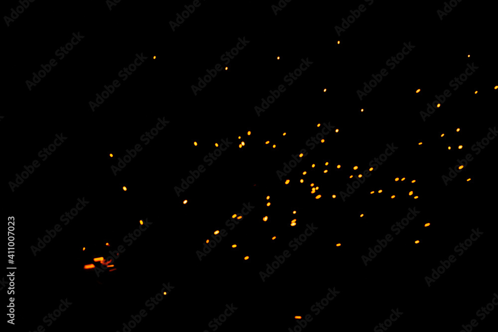 Particles of burning embers fly and glow isolated in the night sky ...