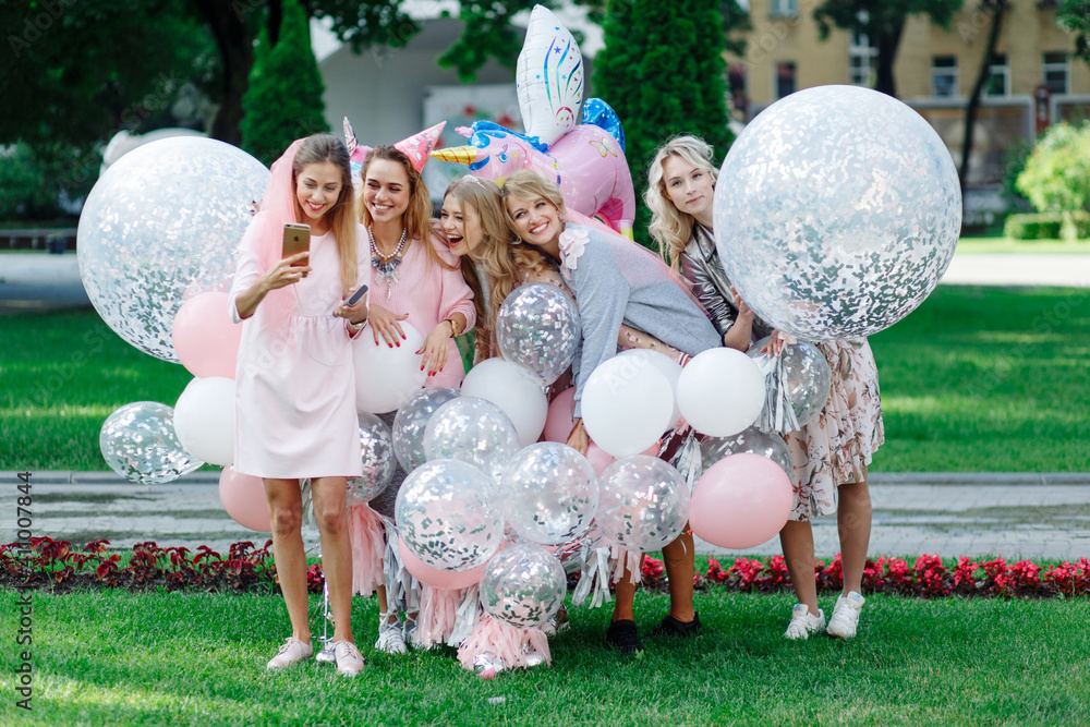Six girls are having fun at a party in the park. They're wearing pink ...
