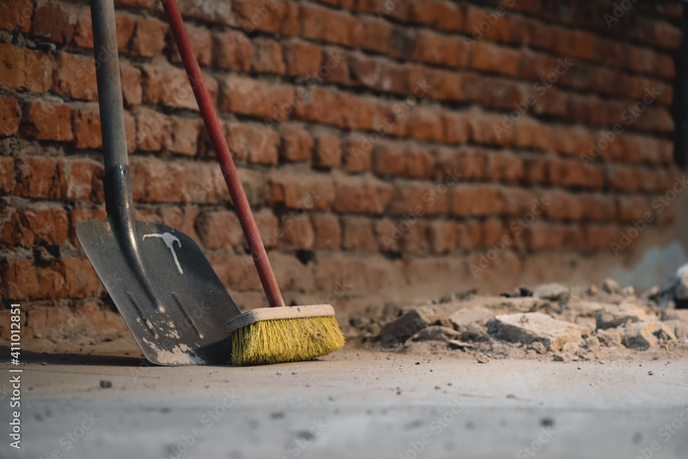 Shovel and broom on the dusty construction site floor background. Stock ...