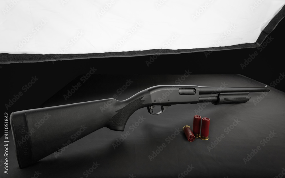 Pump action shotgun on all black with shotgun shells Stock Photo ...