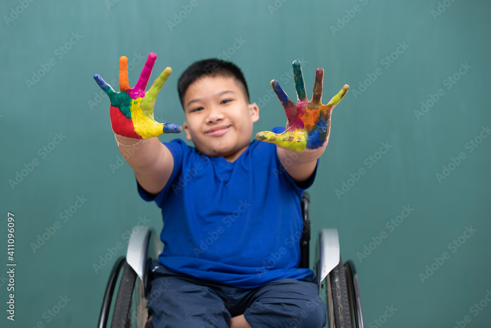 Foto de A disabled boy on wheelchair showing hands with colorful colors ...